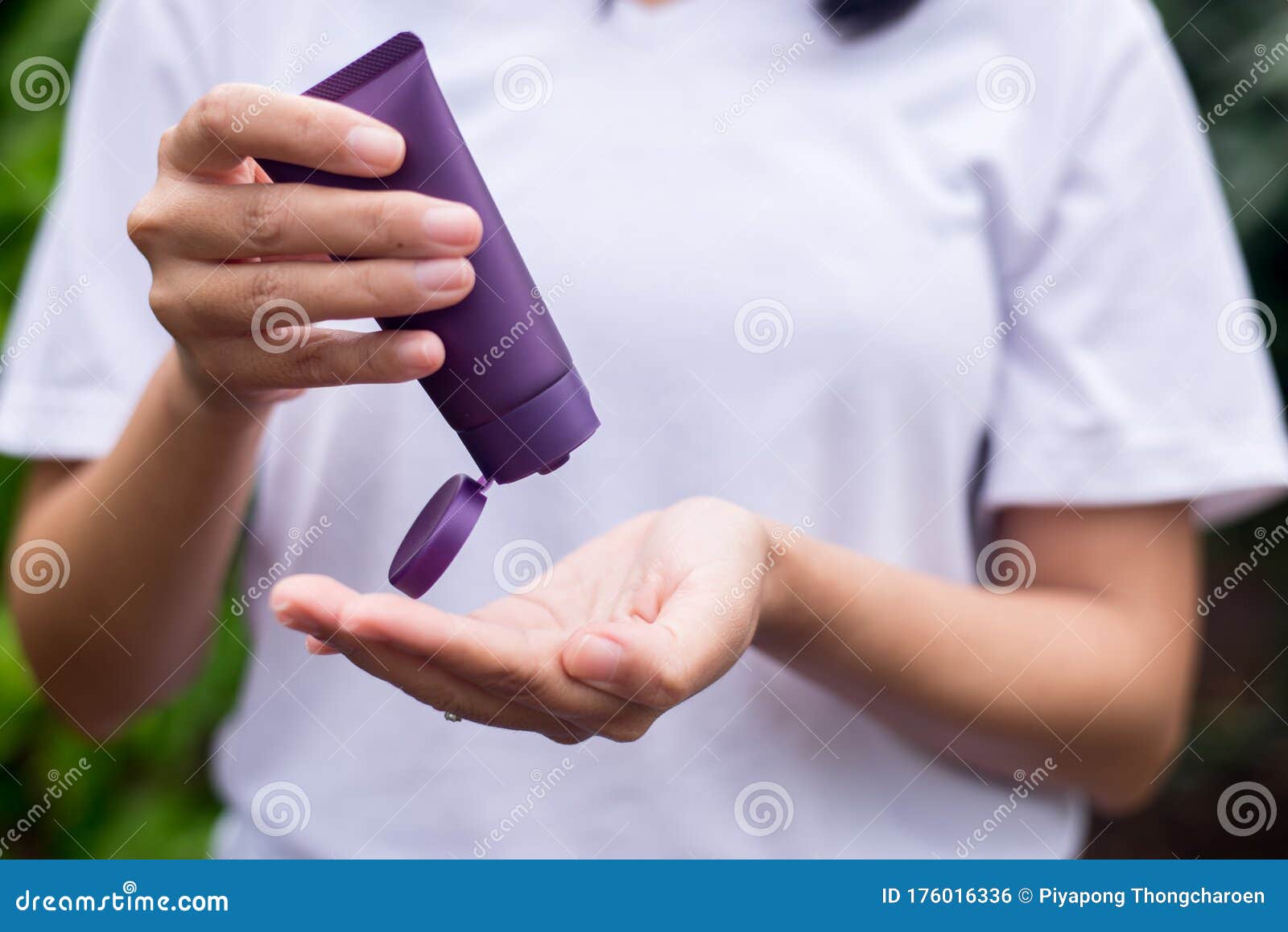 Young Woman Holding And Applying Moisturizing Cream To Hand Concept