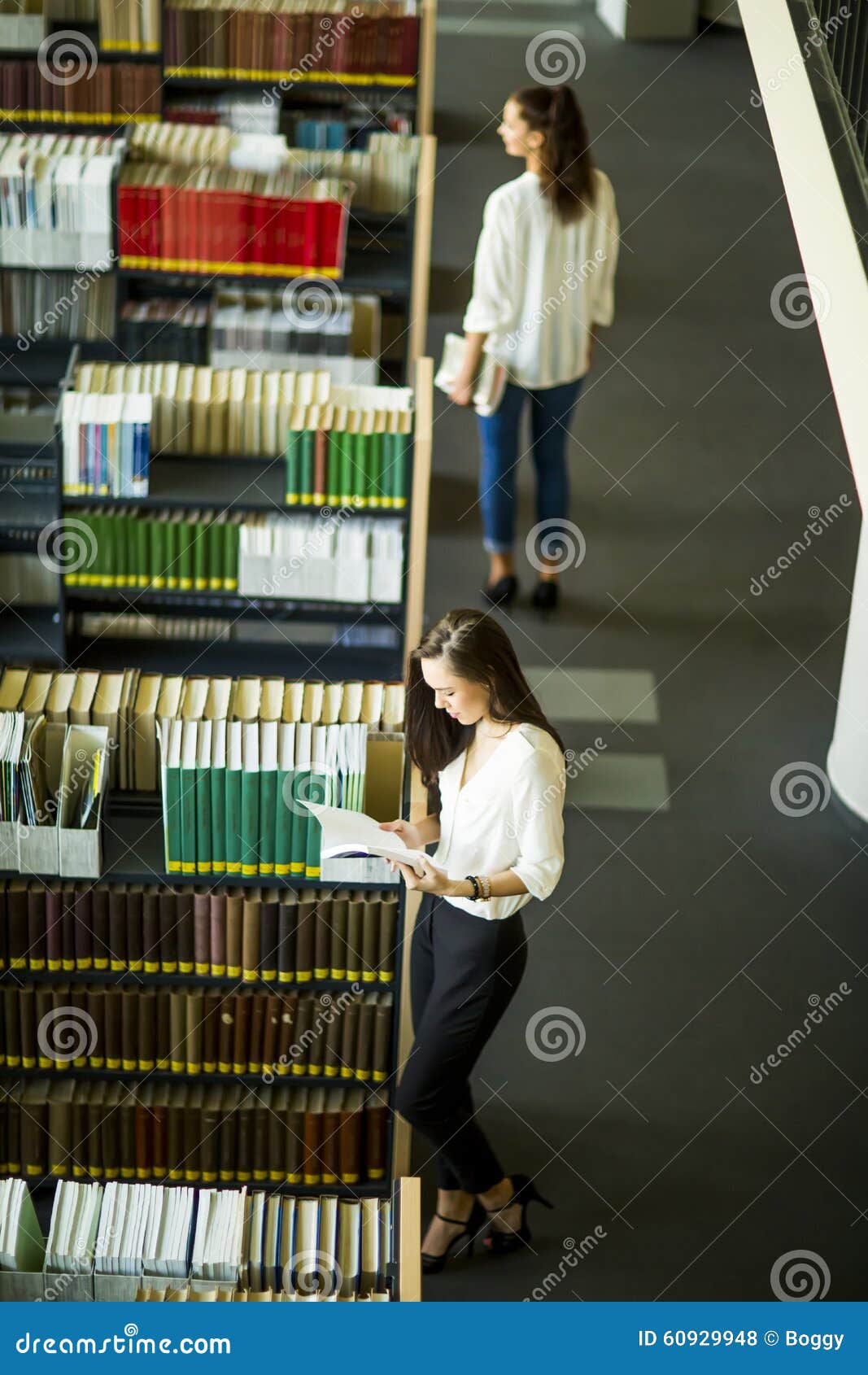 Young women in the library stock photo. Image of books - 60929948