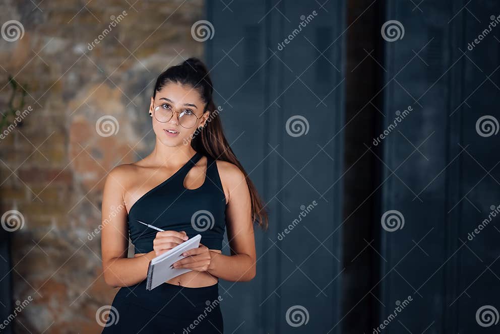 Young Women Standing Writing Down Something into the Notebook. Stock ...