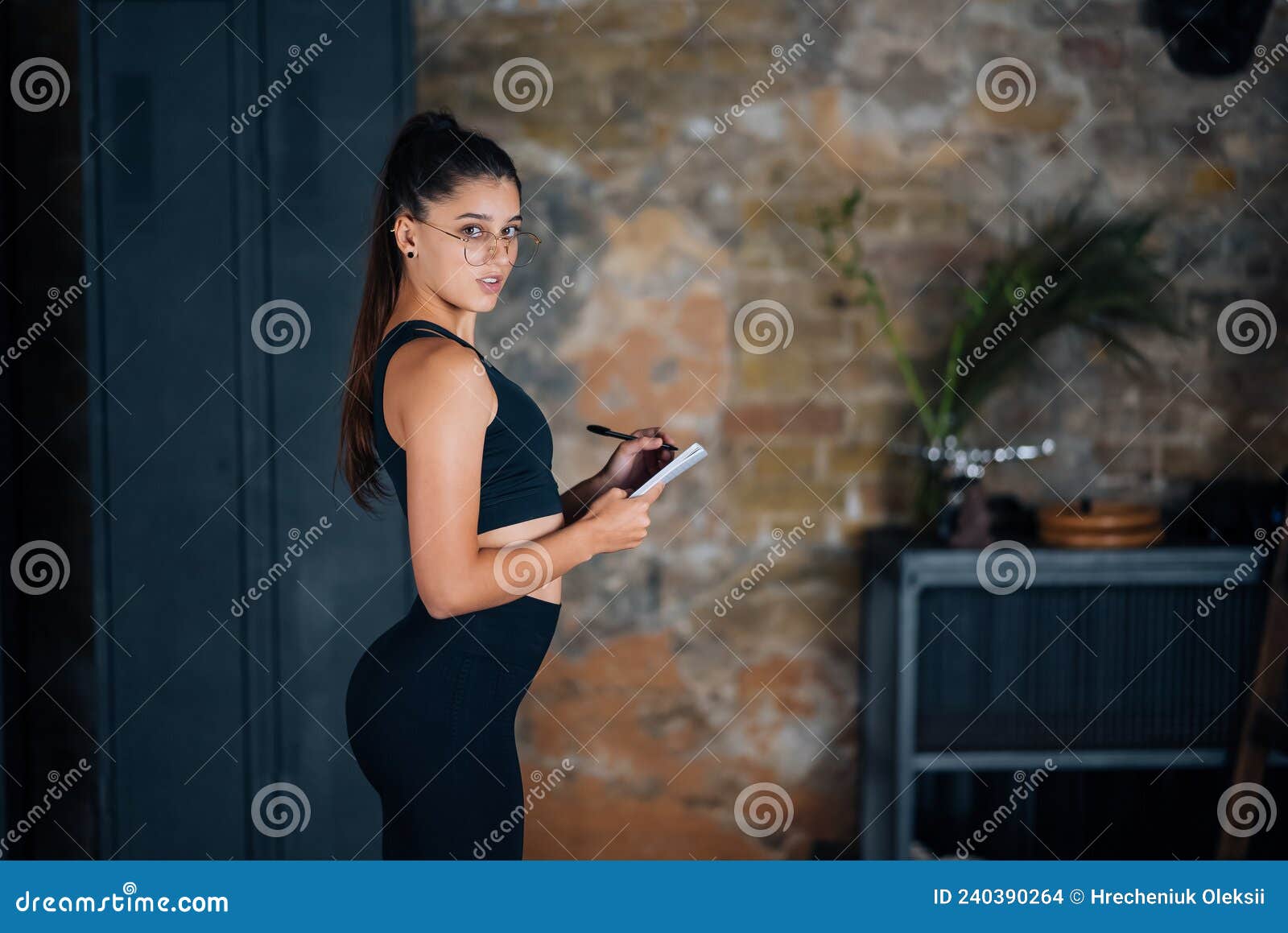 Young Women Standing Writing Down Something into the Notebook. Stock ...