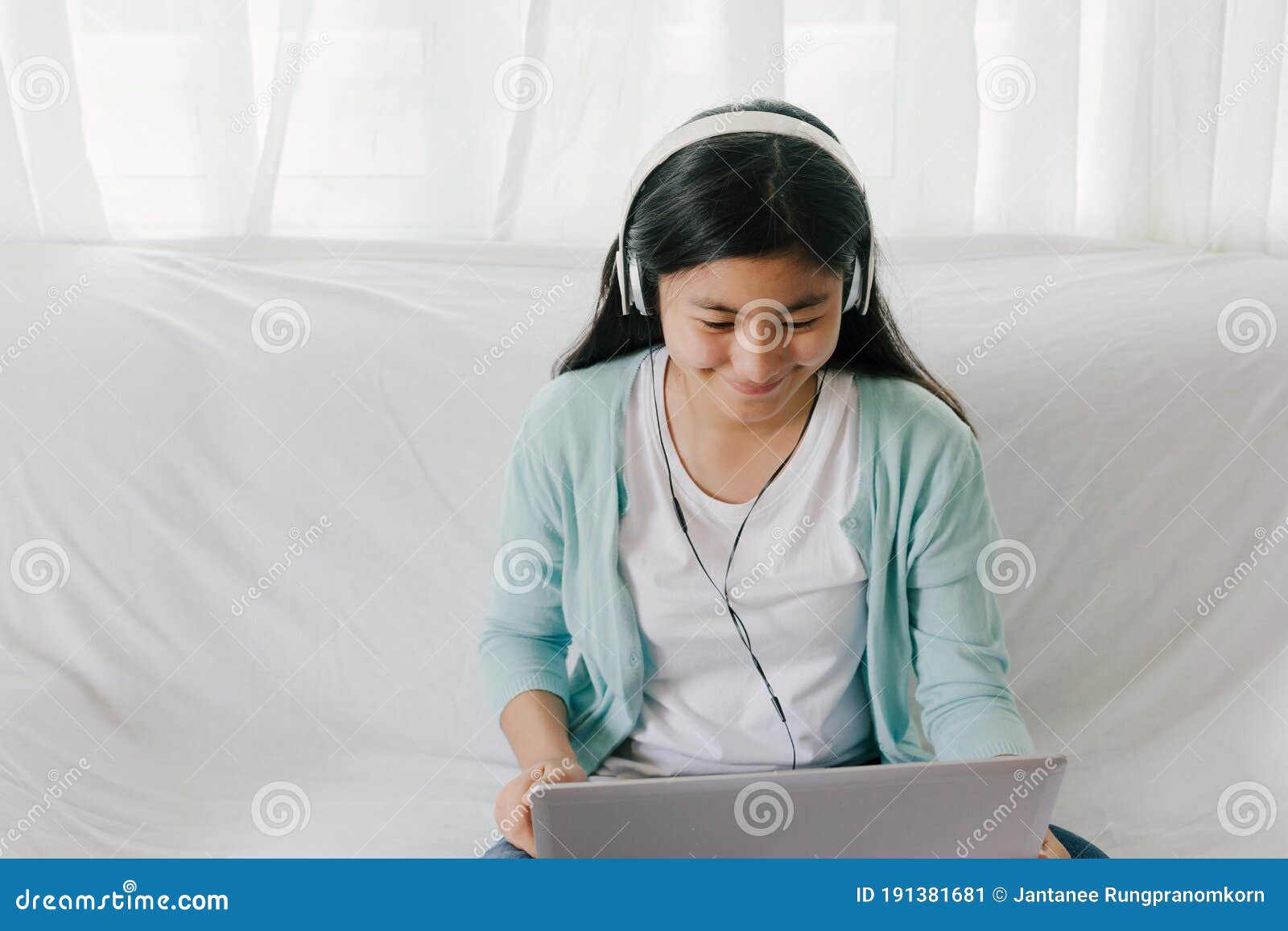 A Young Women Student Sitting and Using Headphones when Studying Stock ...