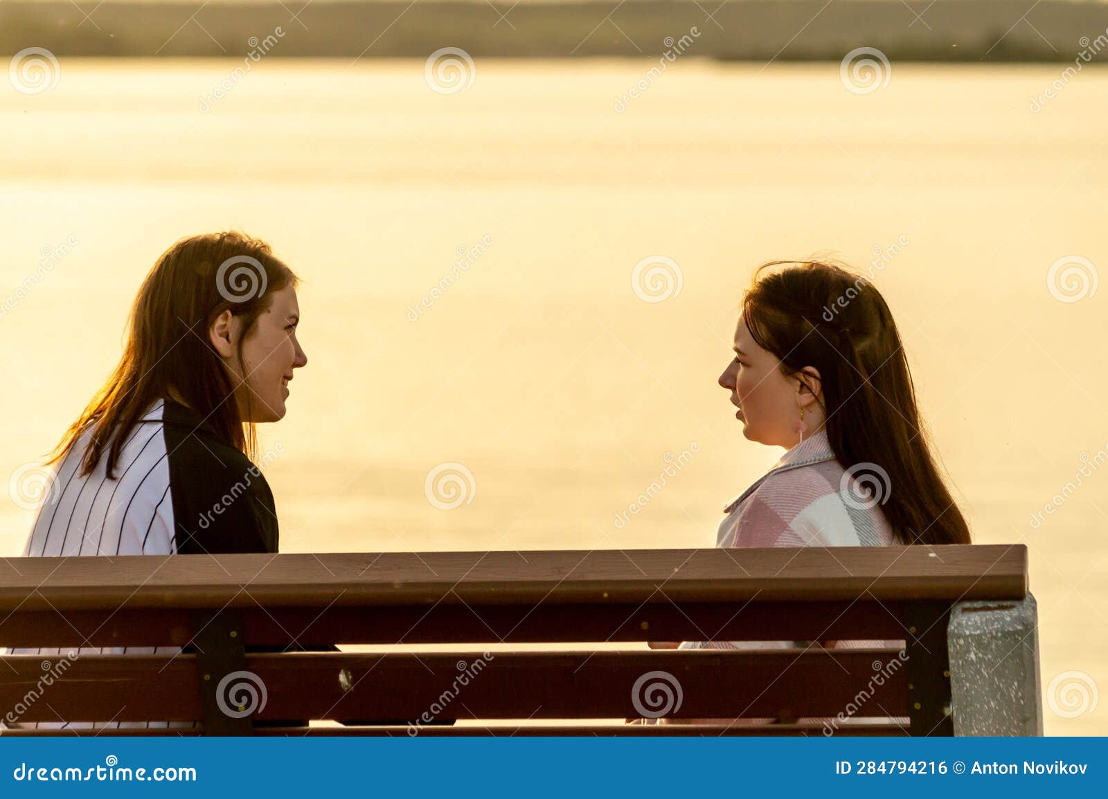 Young Women Talking To Each Other on a Bench Editorial Photo - Image of ...