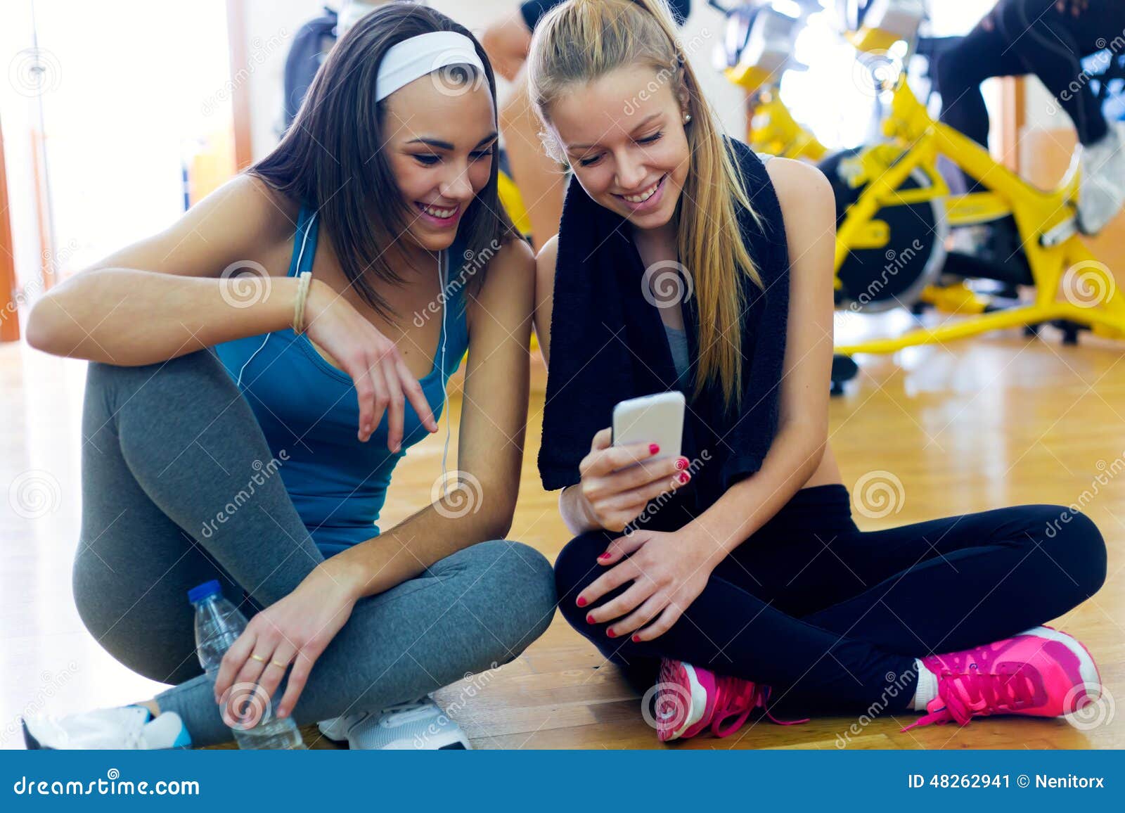 Young Women Using Mobile Phone in the Gym. Stock Image - Image of pink ...
