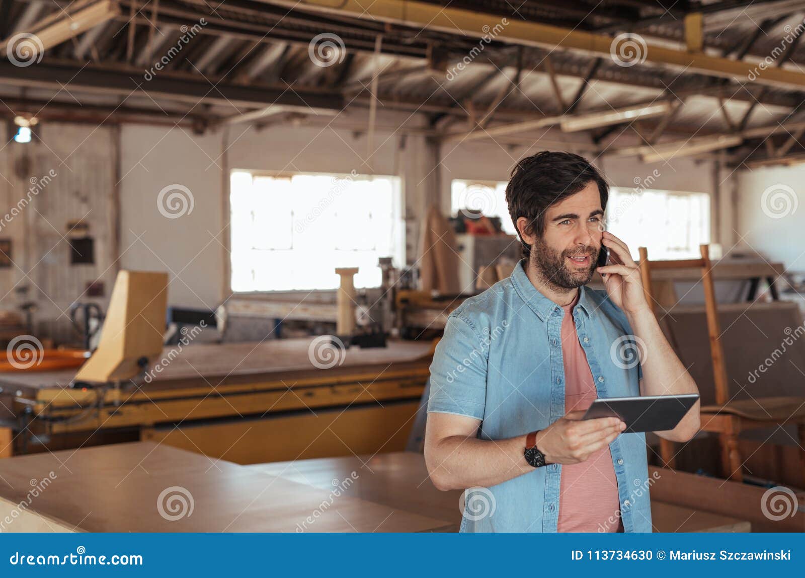 Woodworker Using a Cellphone and Tablet in His Workshop Stock Photo ...