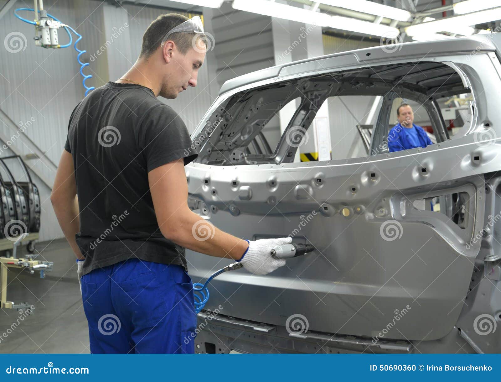 The Young Worker Drills an Opening in a Car Body a Pneumodrill ...