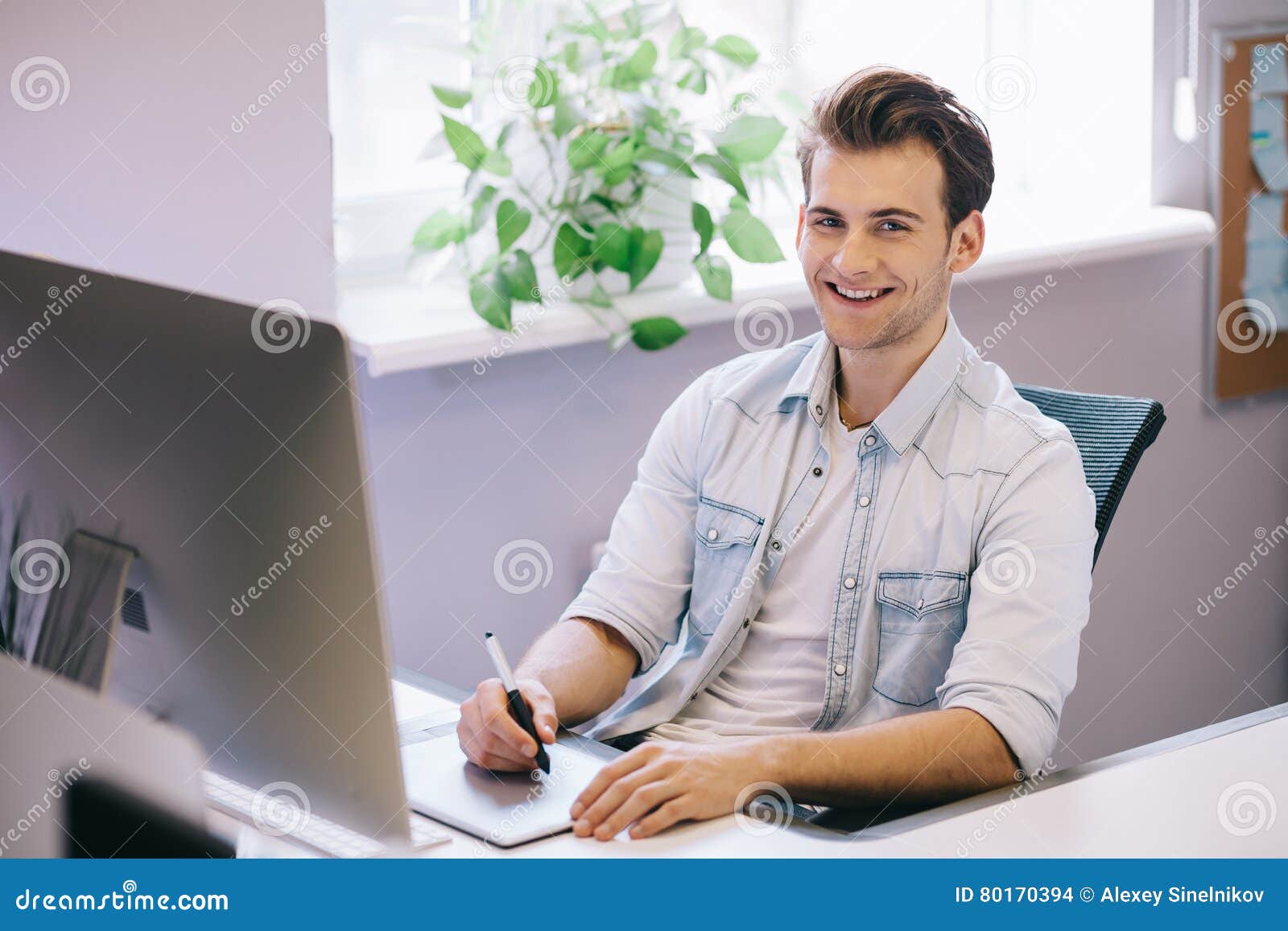 Young Worker Sitting in an Office at the Computer. Freelancer in a Blue ...