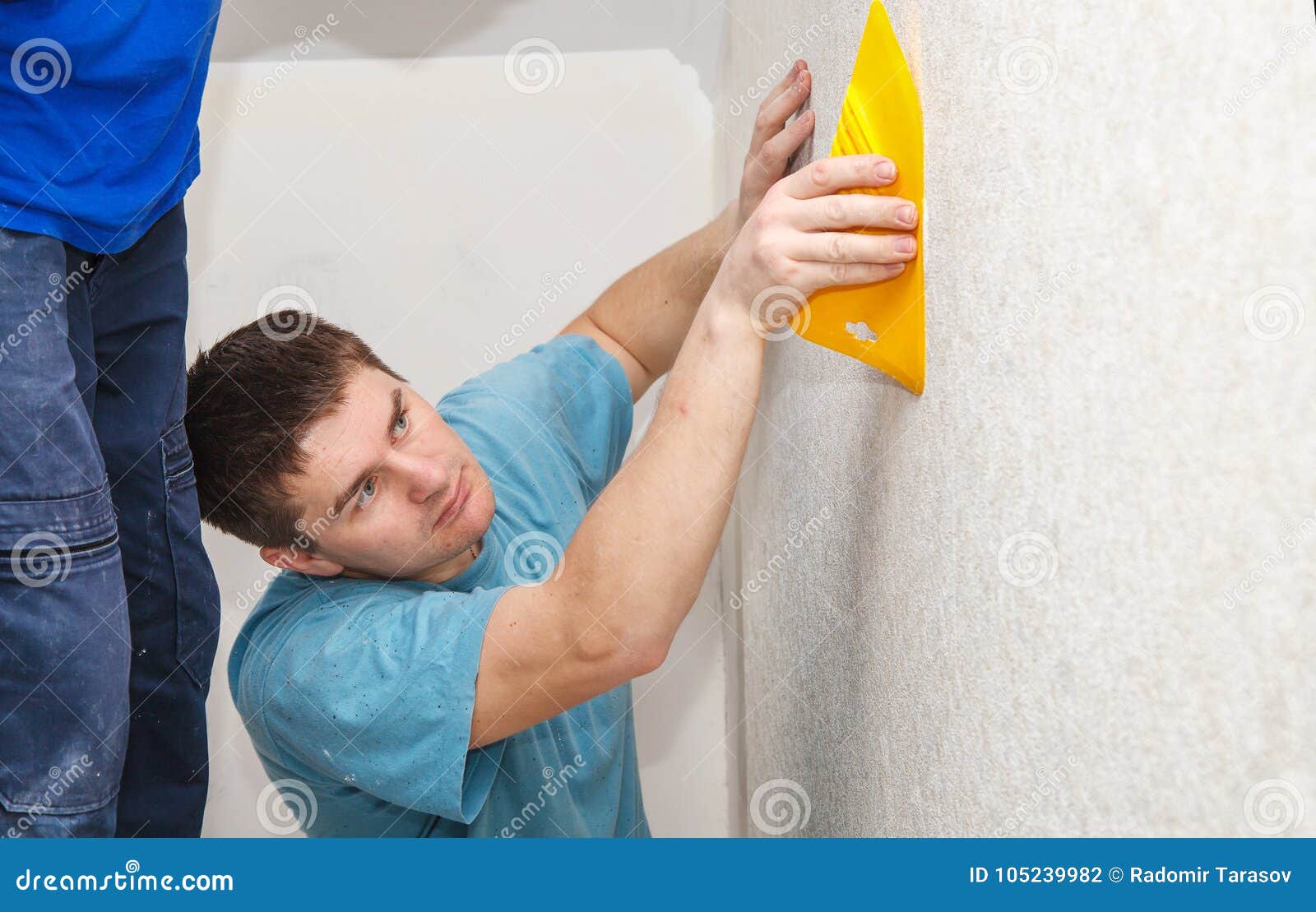 Young Worker Smoothing Wallpaper at Home Stock Photo - Image of house ...
