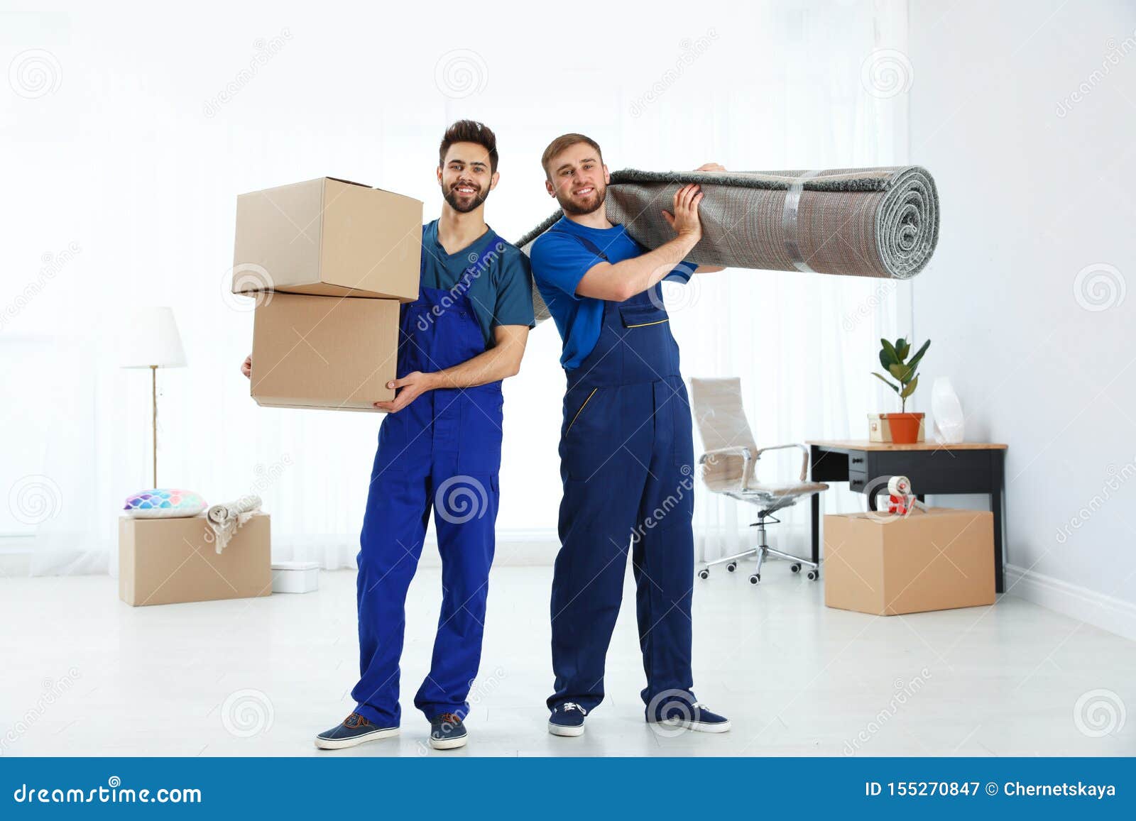 Young Workers Carrying Rolled Carpet and Boxes in Room Stock Image ...