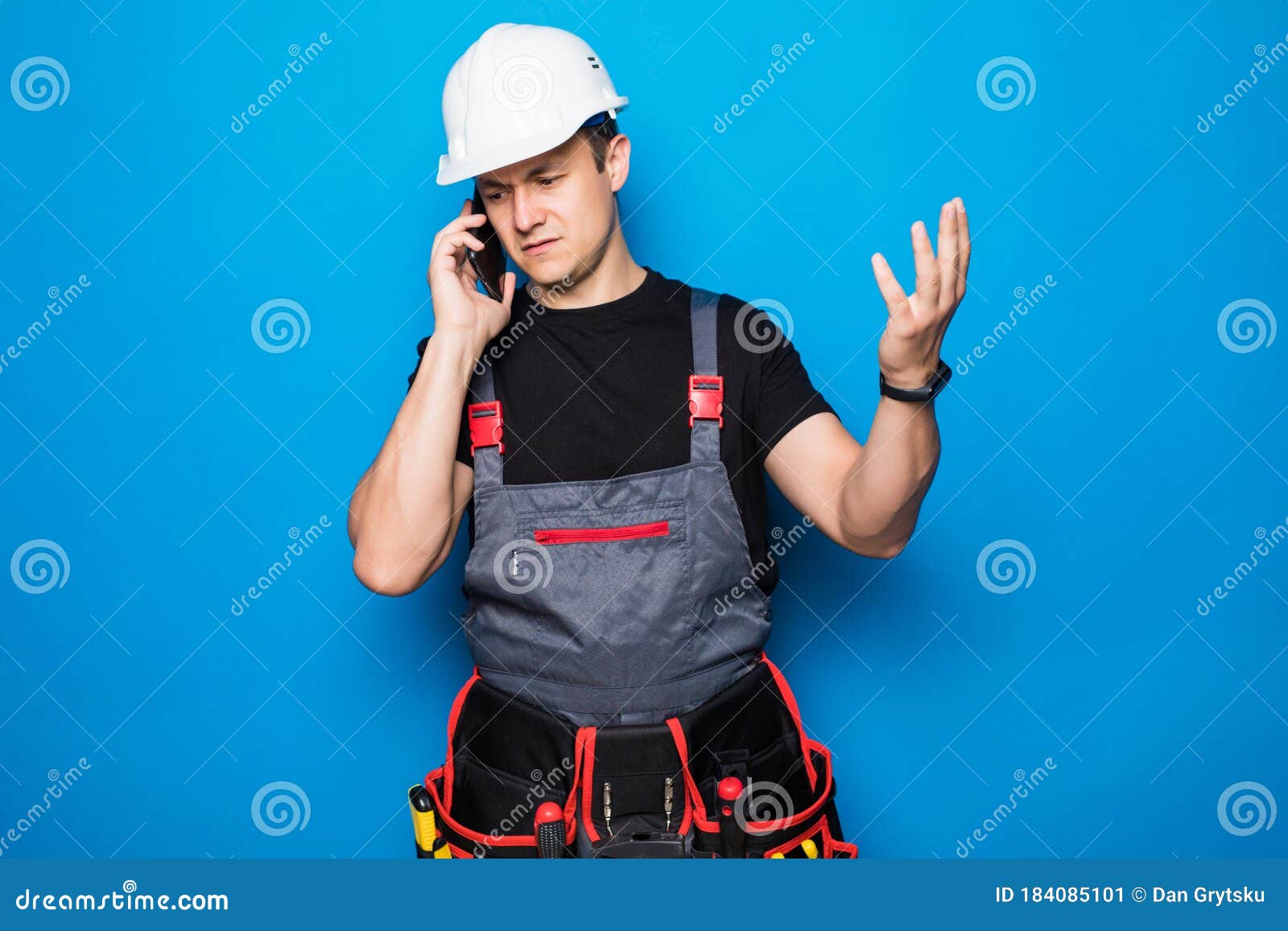 Young Workman with Helmet Making Phone Call and Speaking with Someone ...