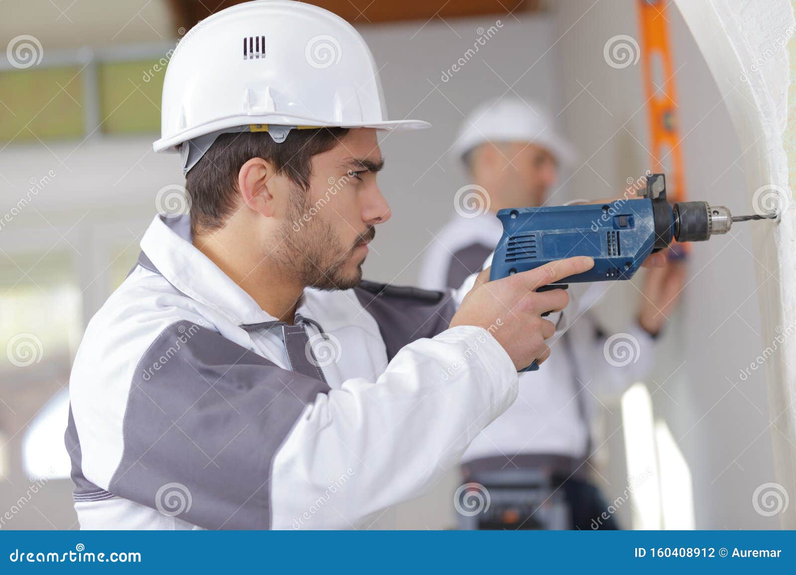 Young Workman Using Drill on Indoor Wall Stock Photo - Image of ...