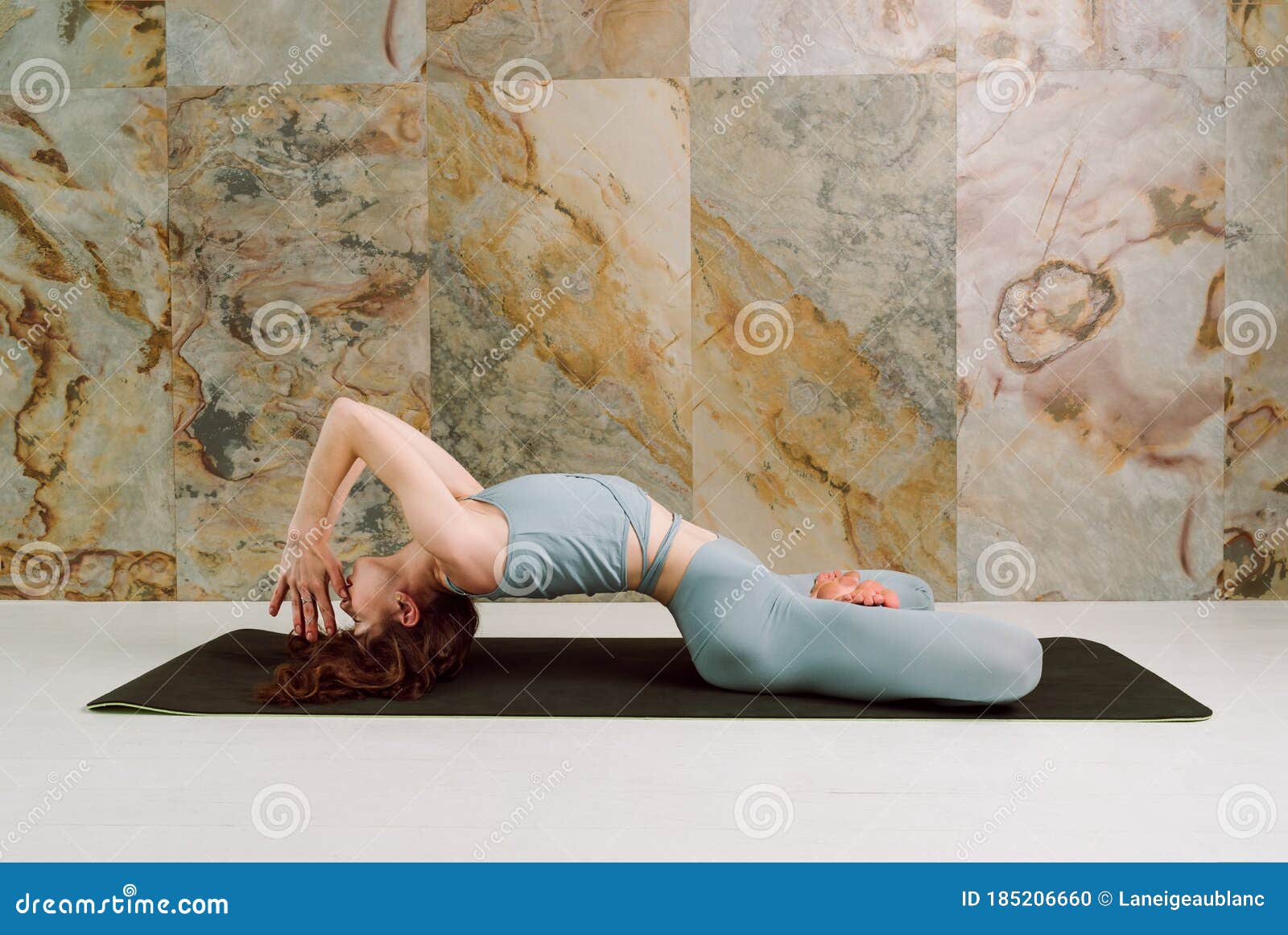 Young Yogini Practicing Matsyasana Pose in Pastel Blue Leggins and Top ...