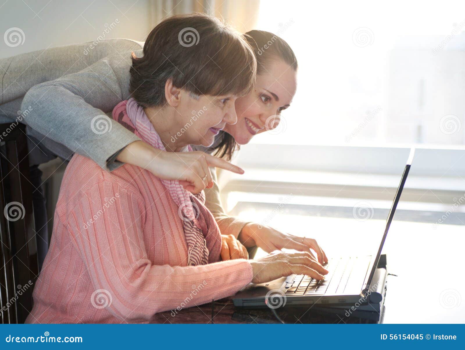 Younger Woman Helping an Elderly Person Using Laptop Computer for ...