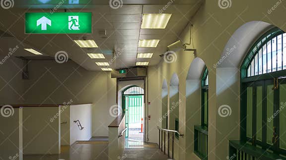 Zielony Znak Wyjścia Awaryjnego Na Suficie W Pustym Tunelu Korytarzowym ... Zielony Znak Wyjścia Awaryjnego Na Suficie W Pustym Tunelu Korytarzowym ...