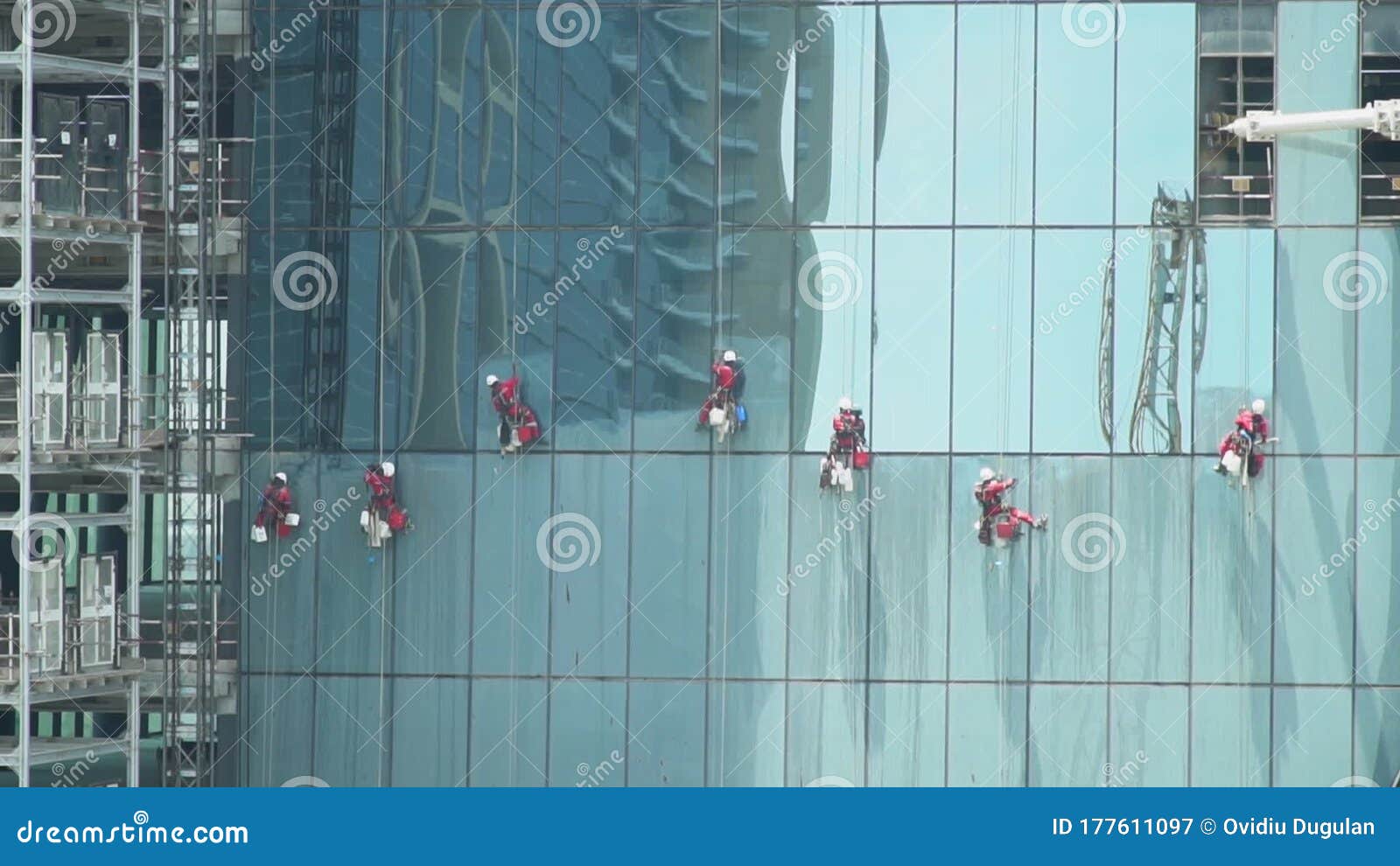 Zooming in O a Group of Workers Cleaning the Windows of a High Rise ...