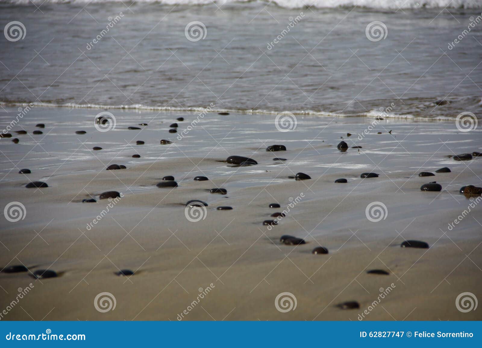 Zwarte Stenen Op Het Strand Stock Afbeelding - Image of eiland, strand ...