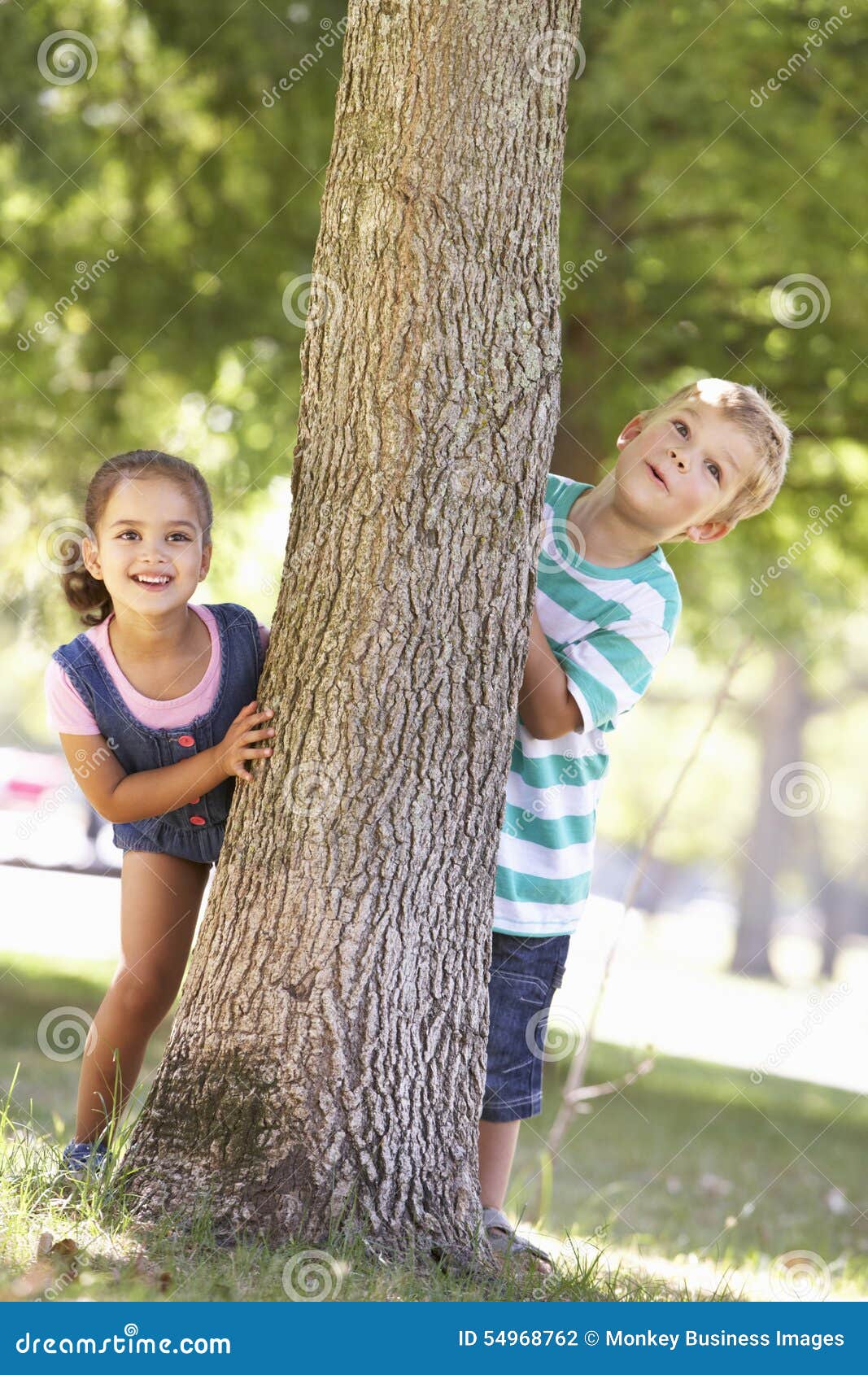 Zwei Kinder, Die Hinter Baum Im Park Sich Verstecken Stockfoto - Bild ...